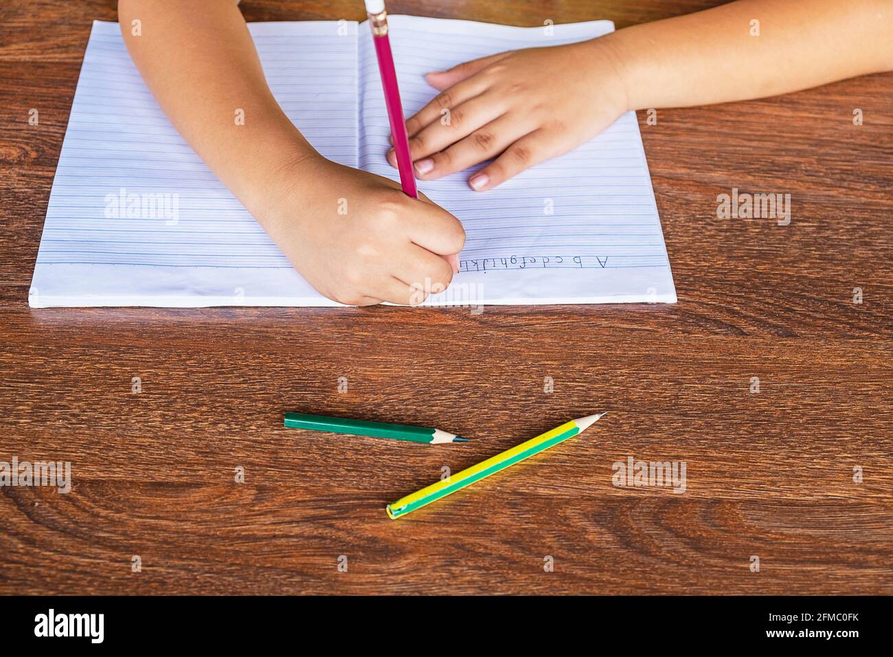 The student's hand is written on paper on the school table Stock Photo ...