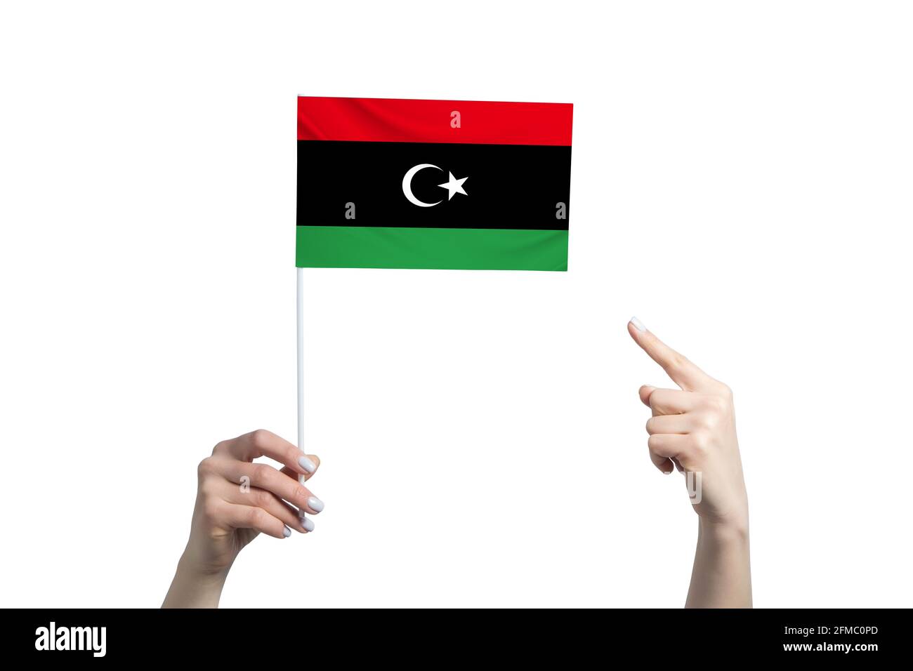 A beautiful female hand holds a Libya flag to which she shows the ...