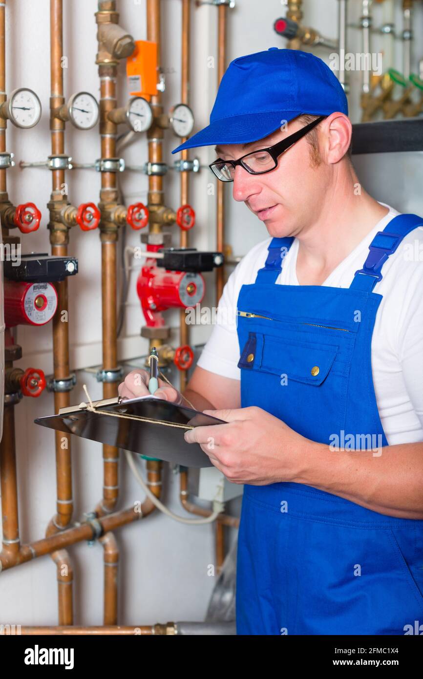 Engineer controlling the heating pipes at the boiler room Stock Photo ...