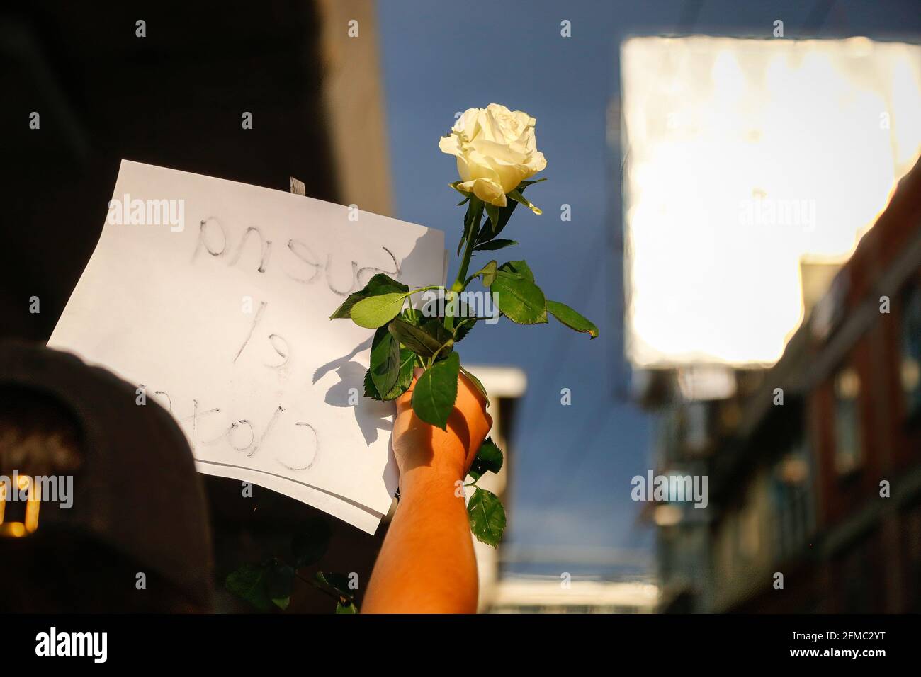 A protester is seen holding a white rose flower during a protest march ...