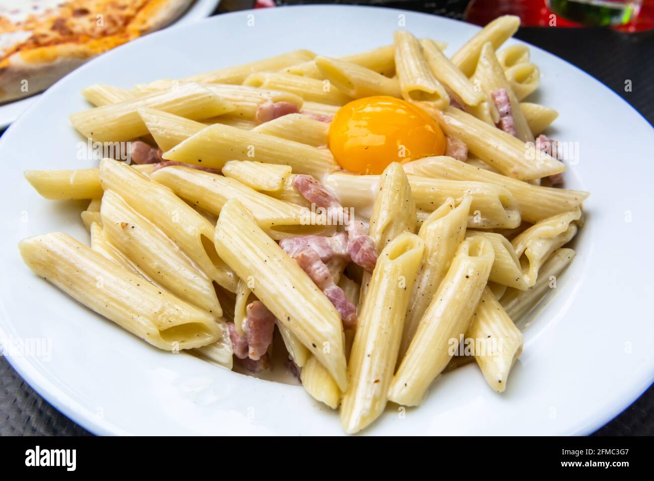 Pasta penne ala carbonara with egg yolk and ham in Paris, France Stock ...