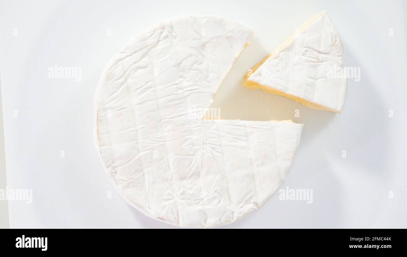 Flat lay. Slicing a large slice of gourmet cheese on a white background ...