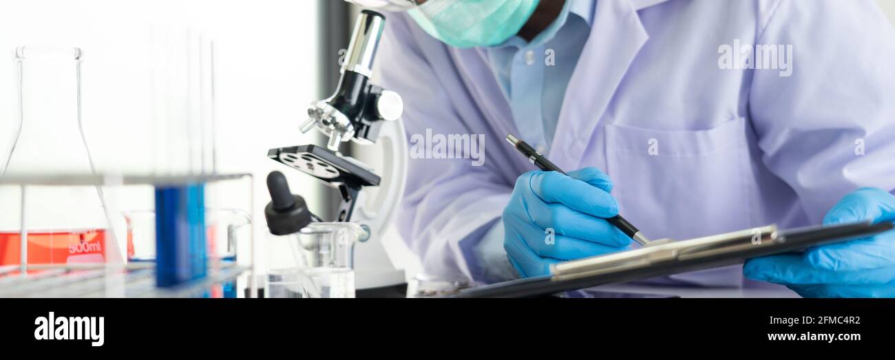 Young Asian scientist Working looking through a microscope doing ...