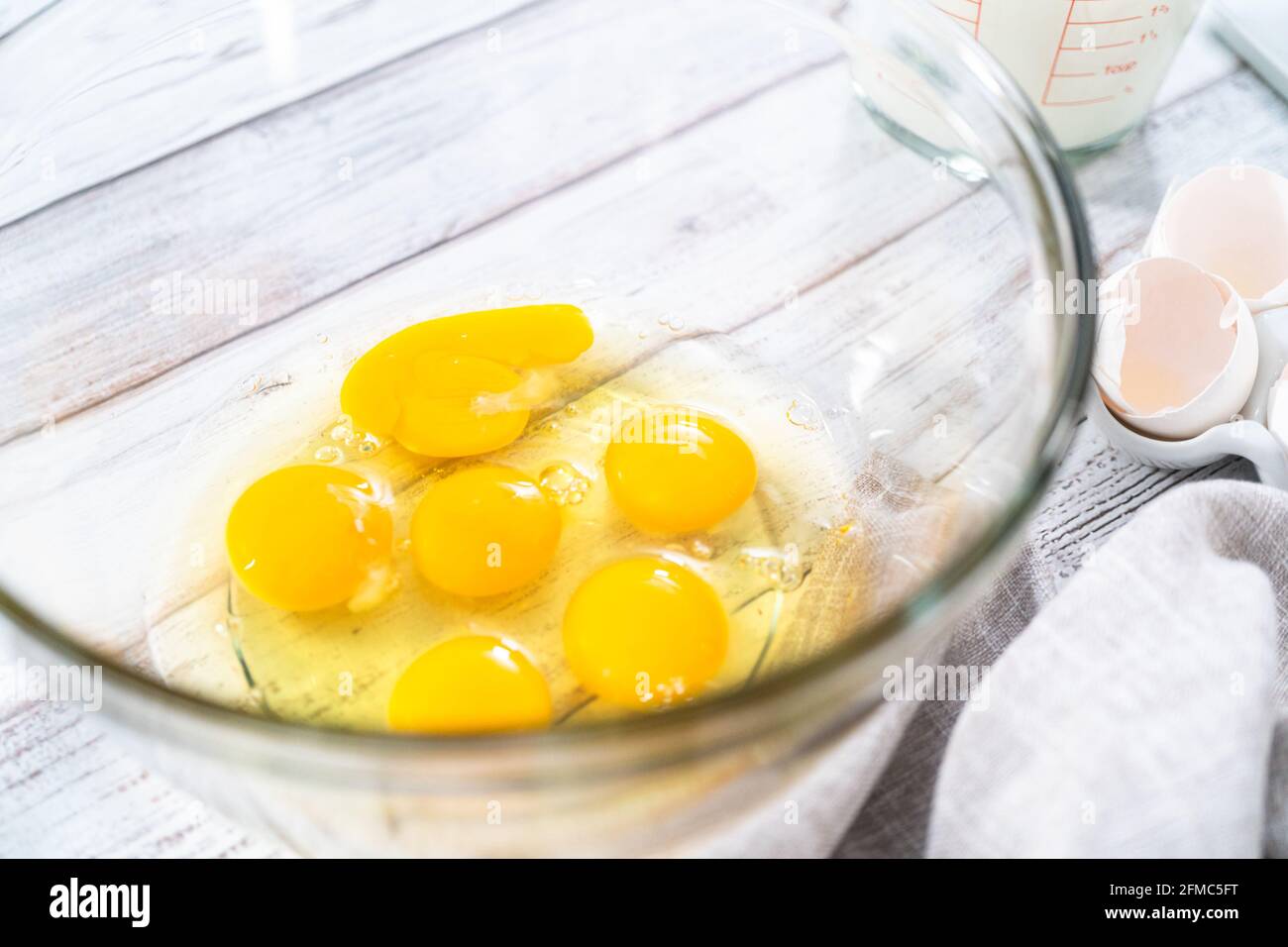 Ingredients in glass mixing bowls to prepare french toast on a wooden ...