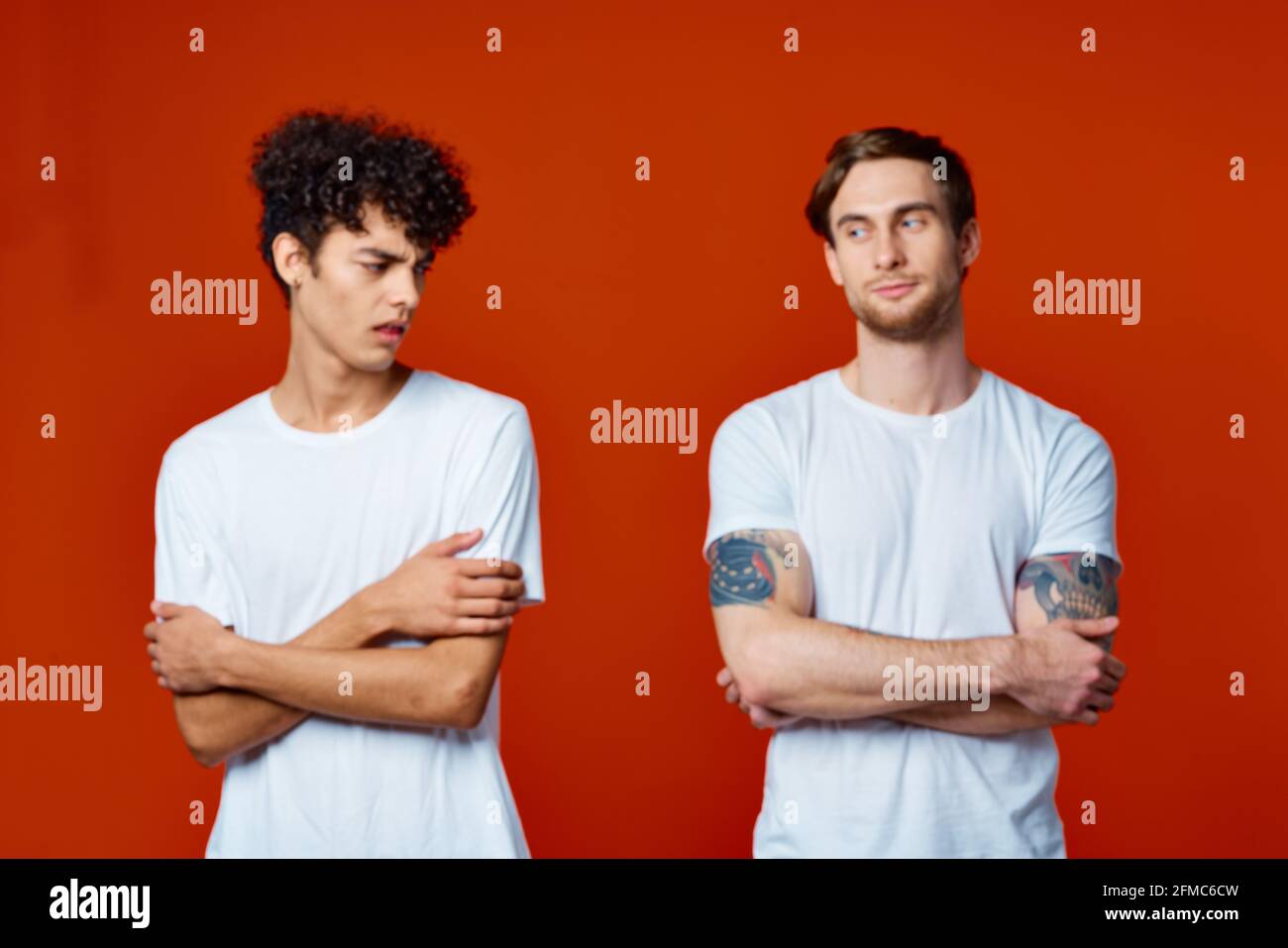 two men in white t-shirts on a red background friendship Stock Photo ...