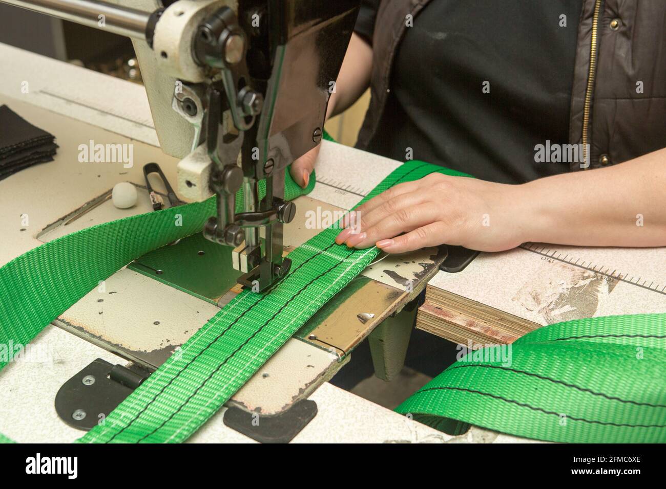 Industrial sewing machine sews a webbing sling. Manufacture of textile ...