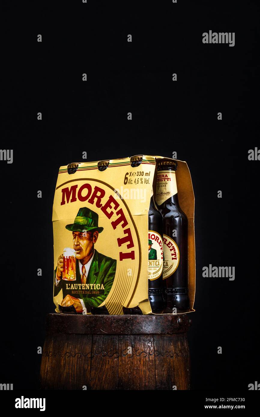 6 pack of Birra Moretti beer on wooden barrel with dark background ...