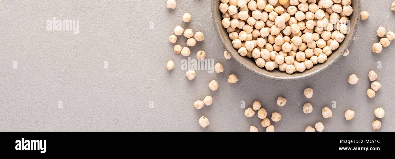 Legumes in bowl and scattered in the background, chickpeas in a plate ...