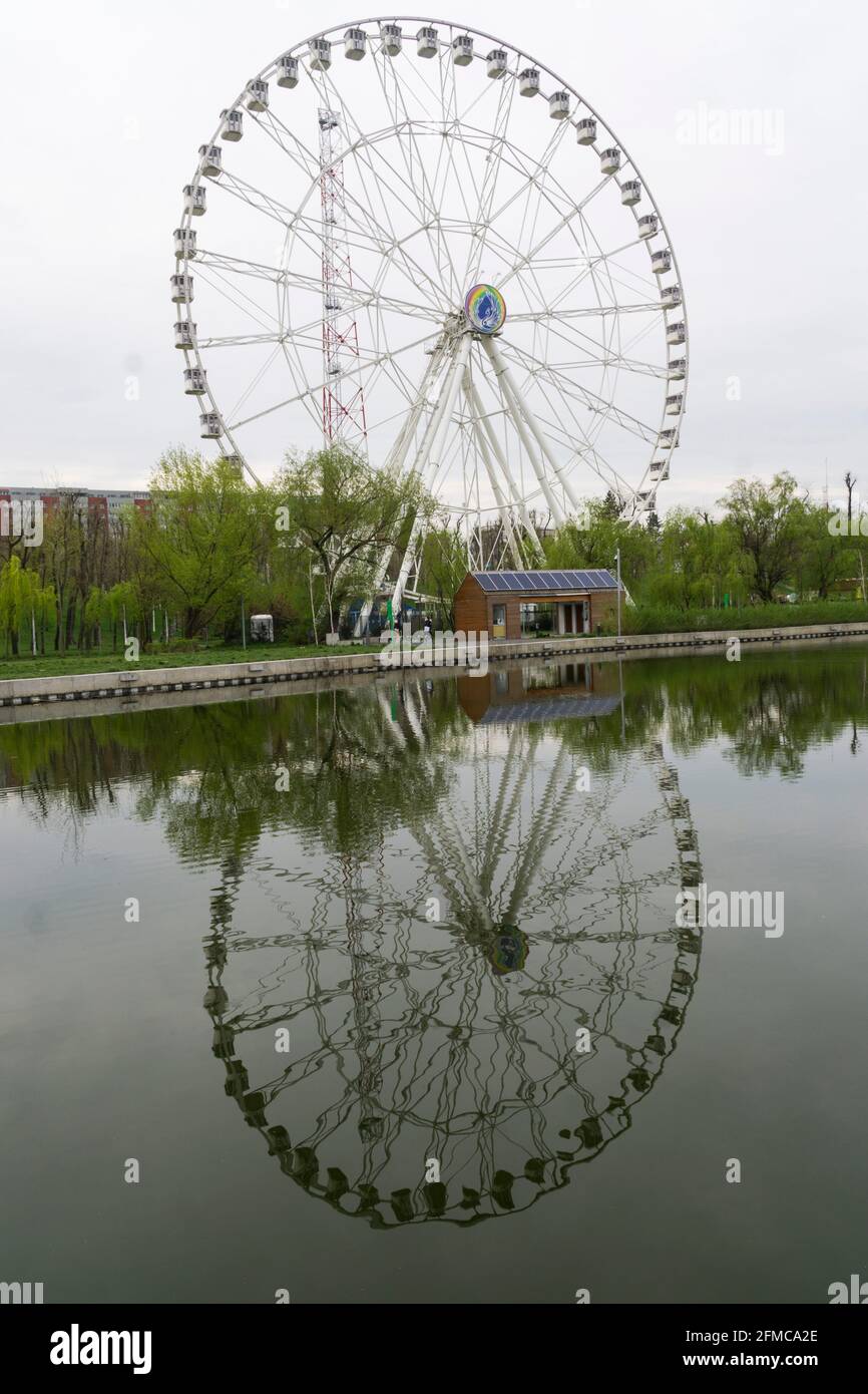 Wheel in the amusement park reflected on water Stock Photo - Alamy