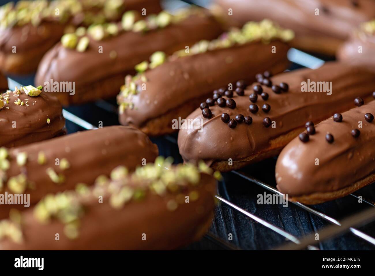 French dessert eclairs or profiteroles with milk chocolate glaze, drops ...