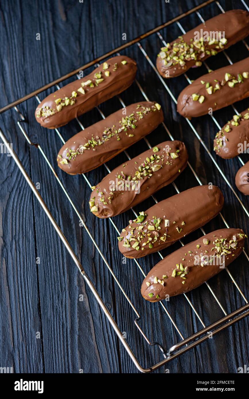 French dessert eclairs or profiteroles with milk chocolate glaze, drops ...