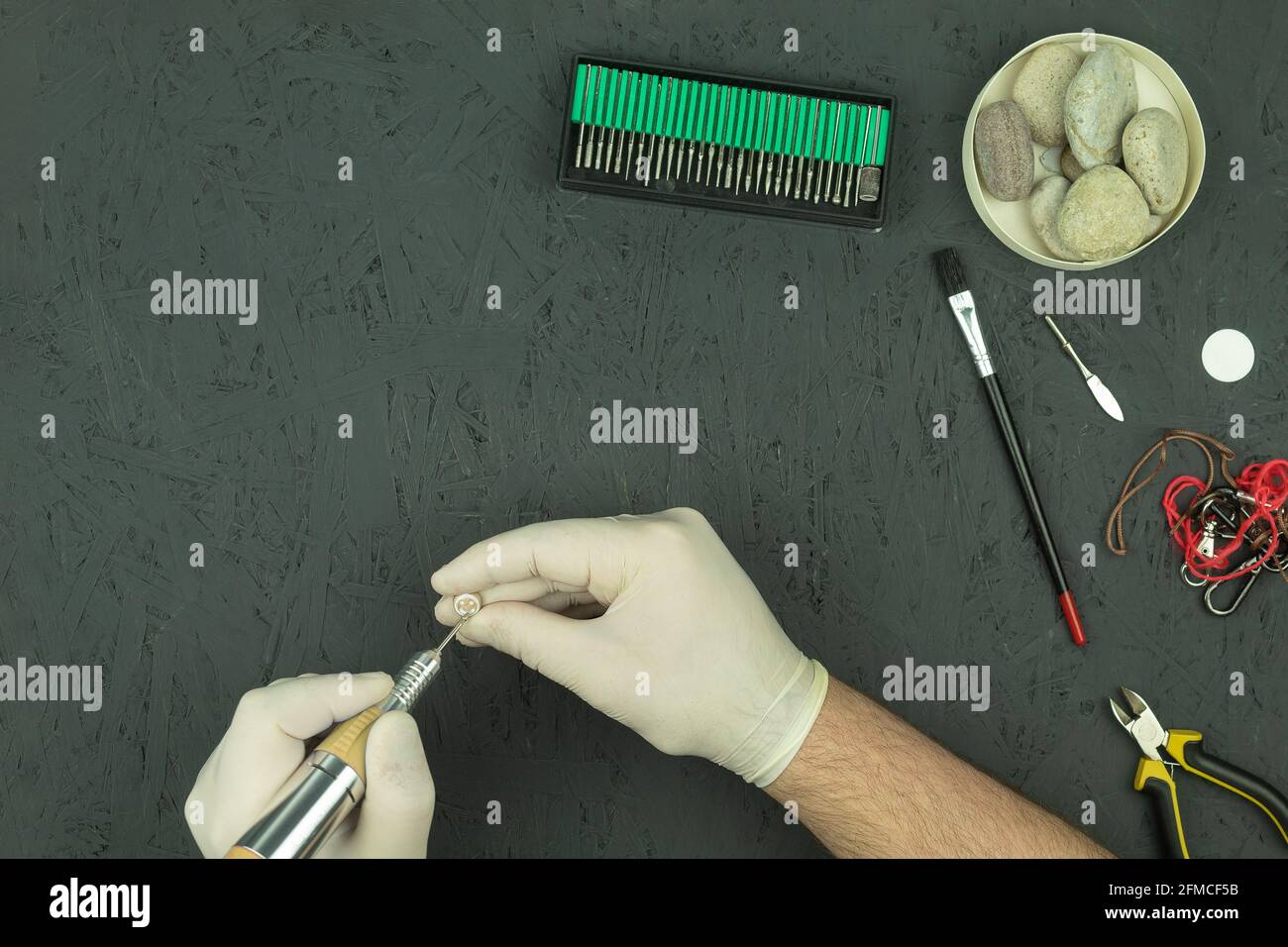 Stone processing with an engraving machine. The man's hands are ...