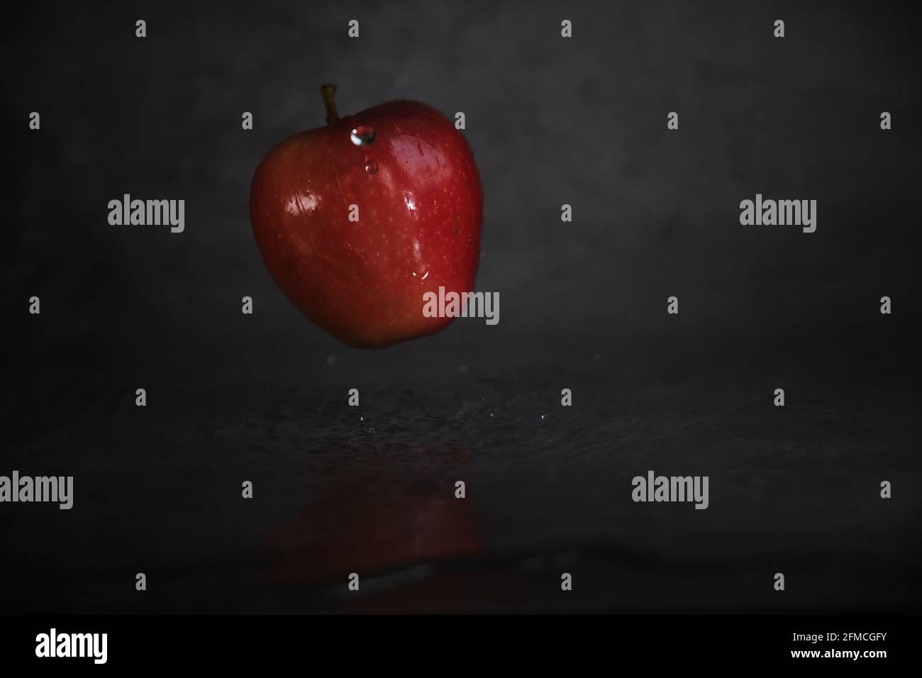 floating in the air red apple dark background Stock Photo - Alamy