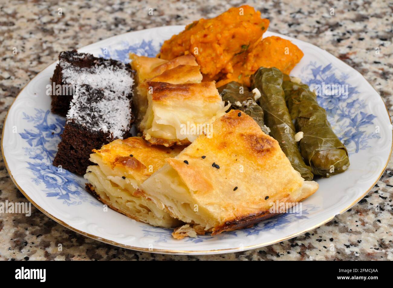 Snack Turkish pastry, cocoa cake, stuffed leaves, on granite in plate ...