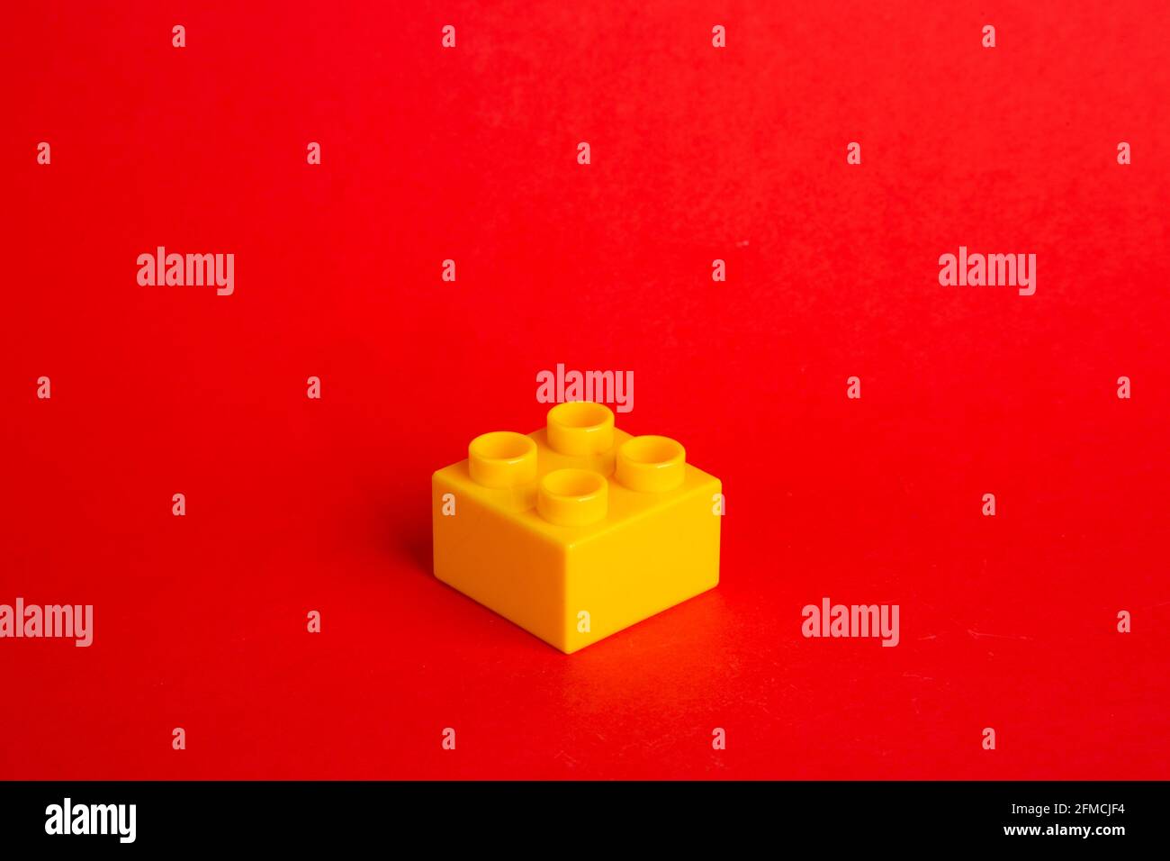 Plastic building blocks on red background Stock Photo - Alamy
