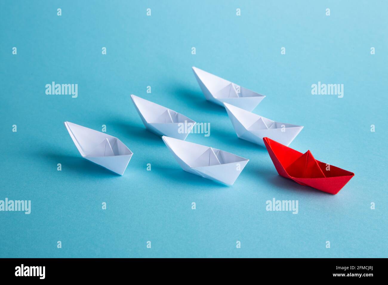 Leadership concept. Red leader paper ship leading among others on blue ...
