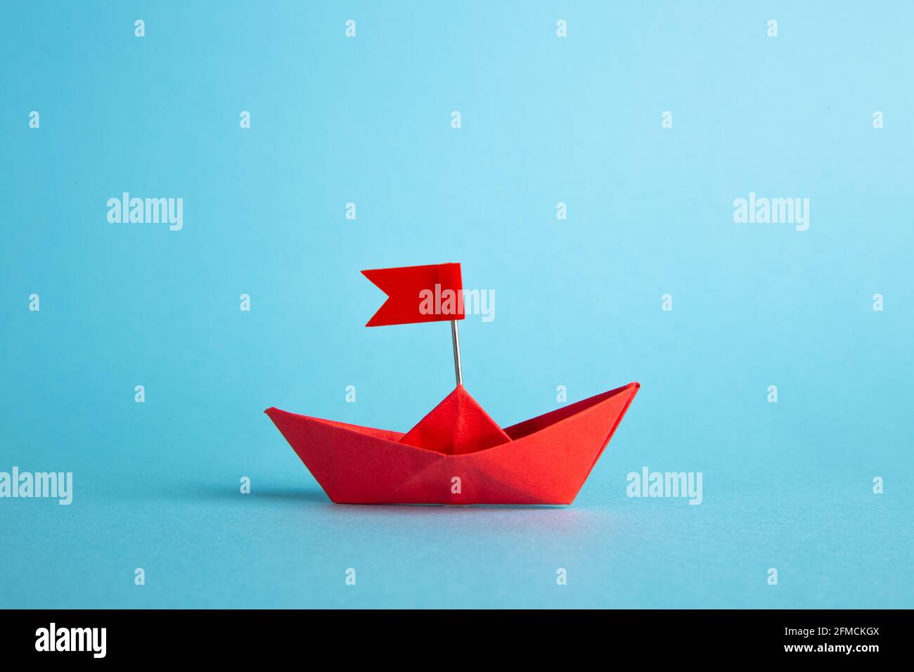 Leadership concept. Red leader paper ship leading among others on blue ...