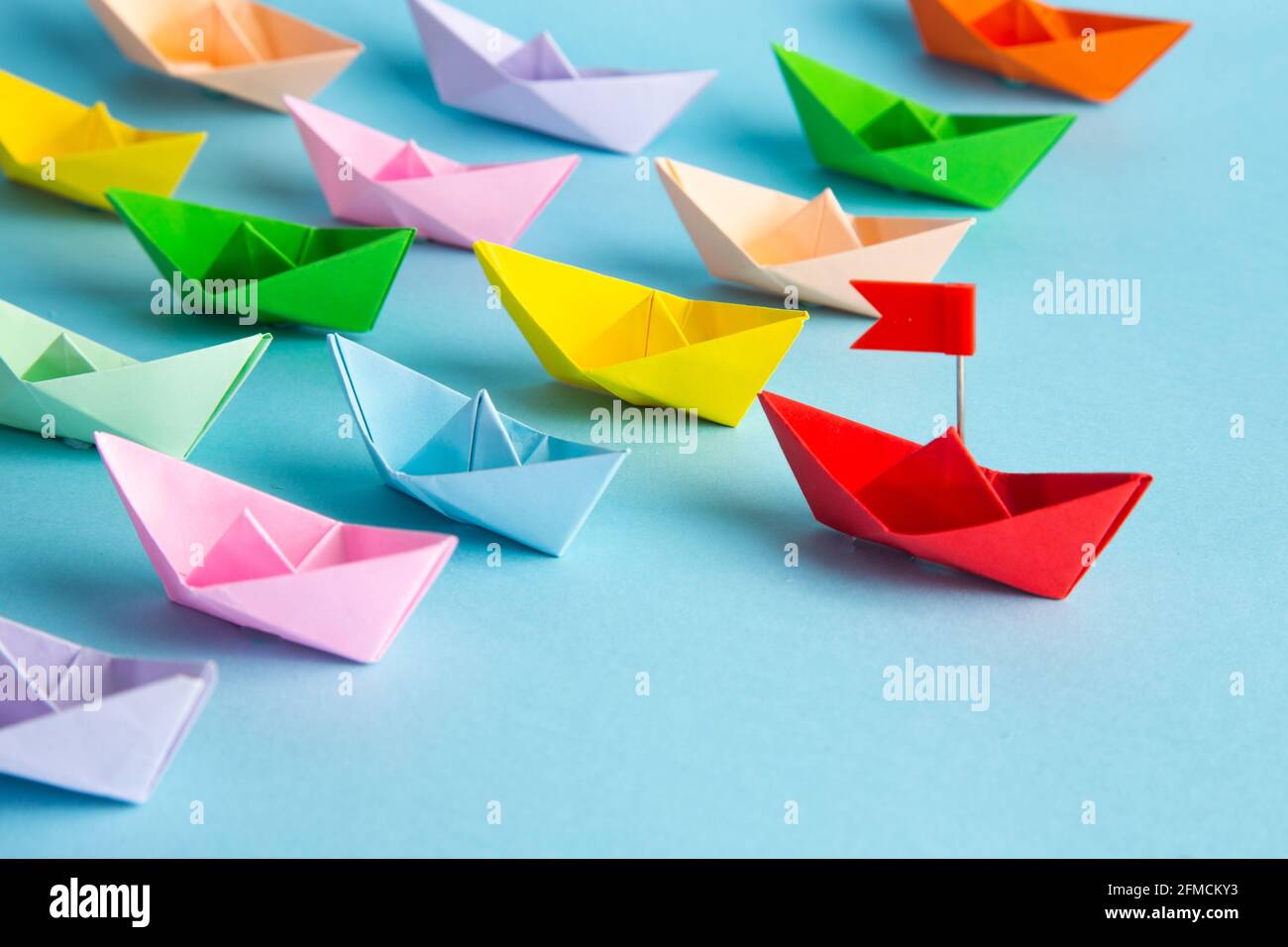 Leadership concept. Red leader paper ship leading among others on blue ...
