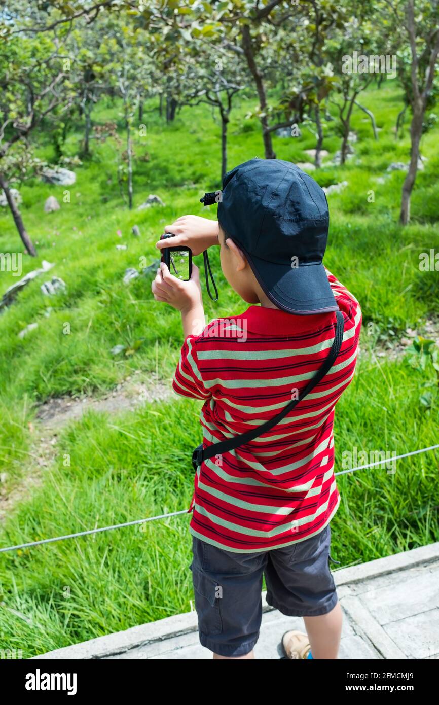 Back view of asian boy with camera at national park . Child relaxing ...