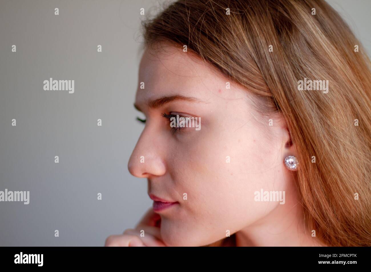 Profile shot of a brooding pretty female in the light background Stock ...