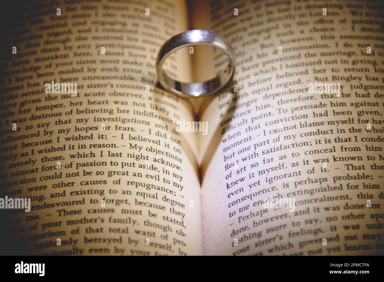 Heart shaped shadow of wedding ring on a book spine / Still Life ...
