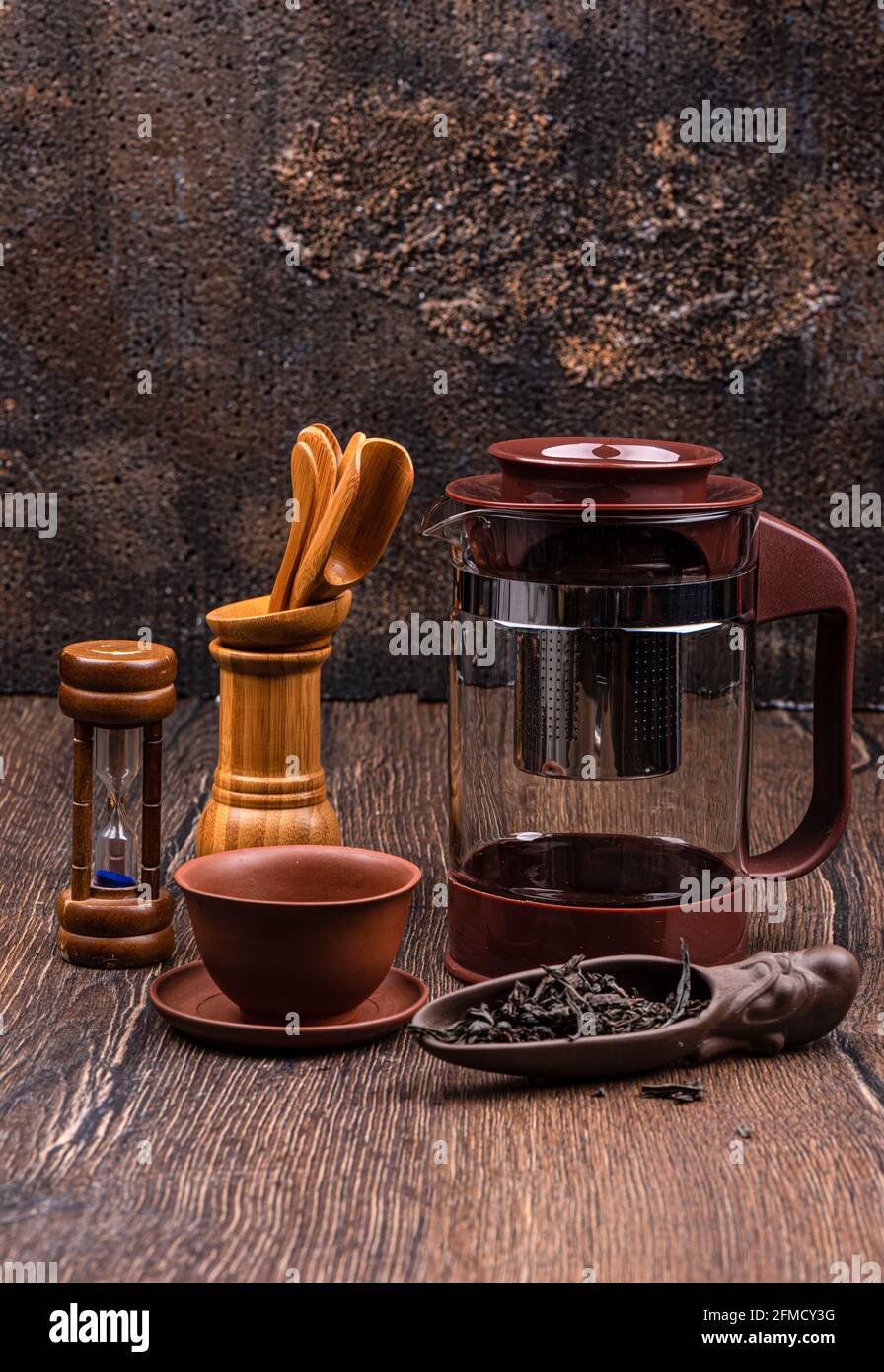 Set for brewing tea on a wooden table. Clay spoon with black tea ...