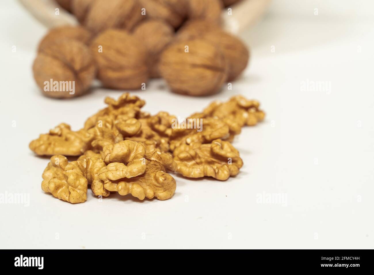 walnut kernels and whole nuts on a light background Stock Photo - Alamy