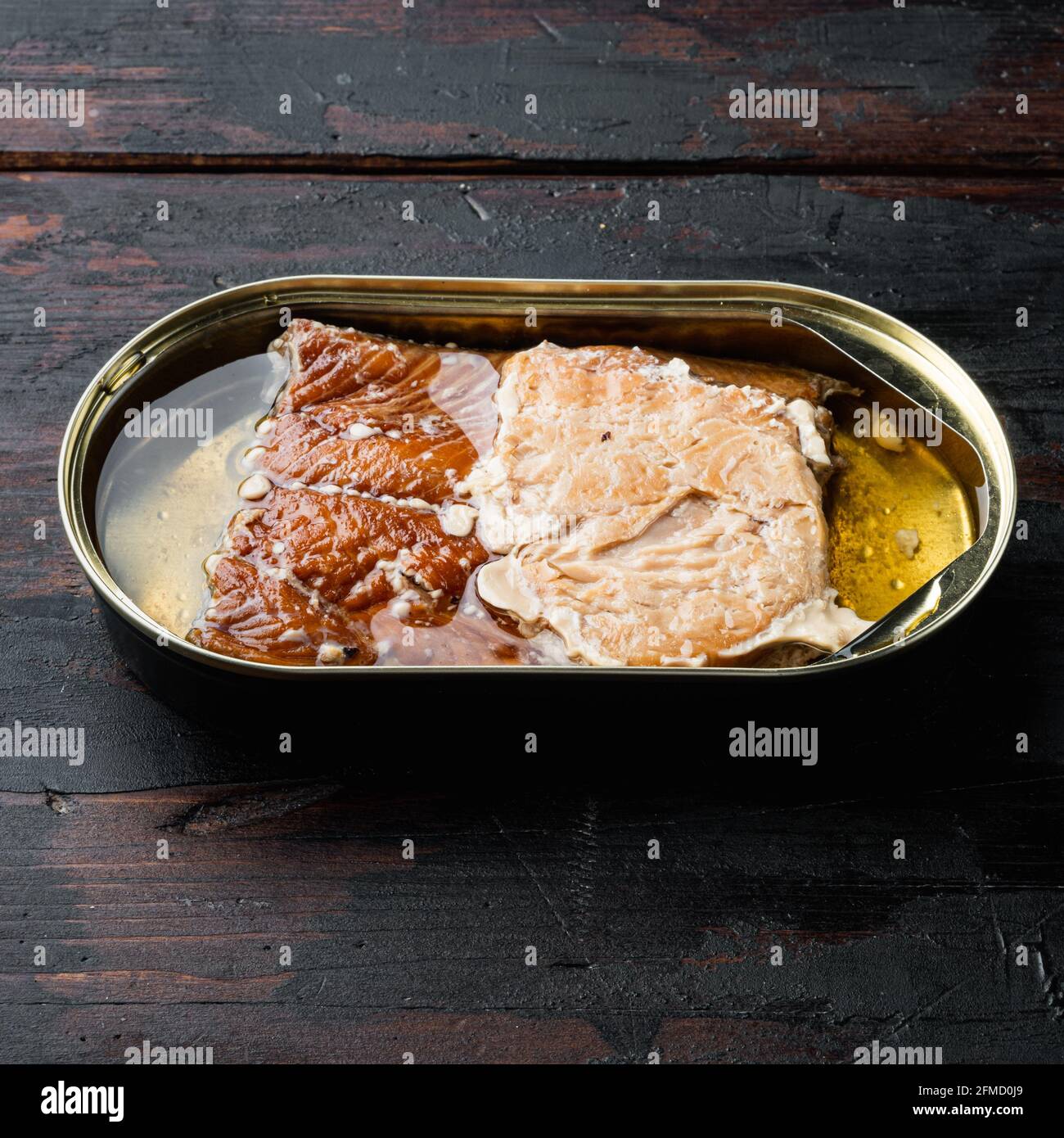Canned Smoked Trout Fillets set, in tin can, on old dark wooden table ...