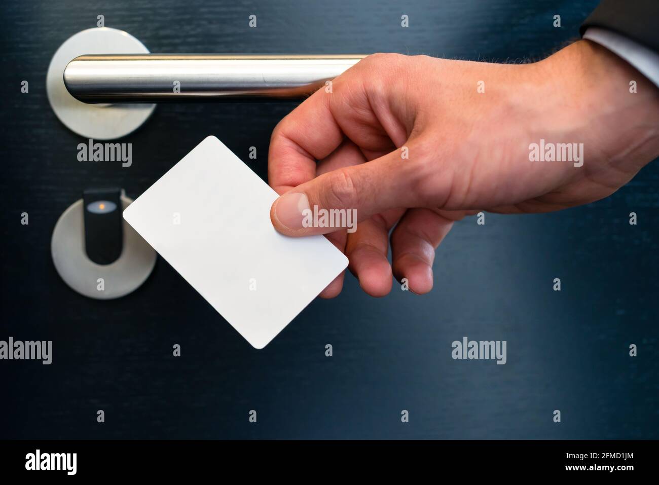 Hotel door - Young man holding a keycard in front of the electronic ...