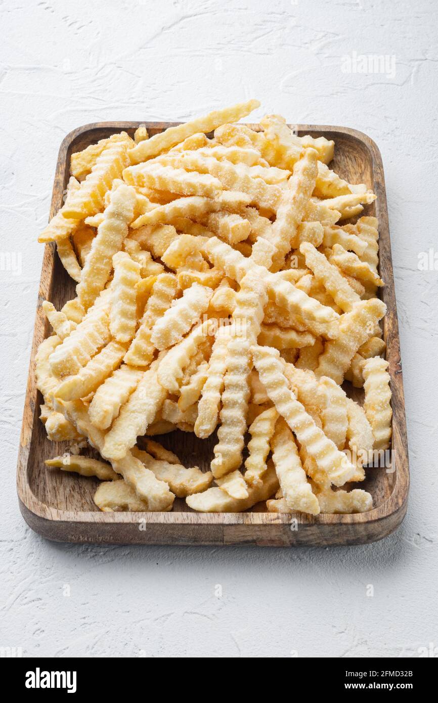 Frozen oven chips sliced potato set, on wooden tray, on white ...
