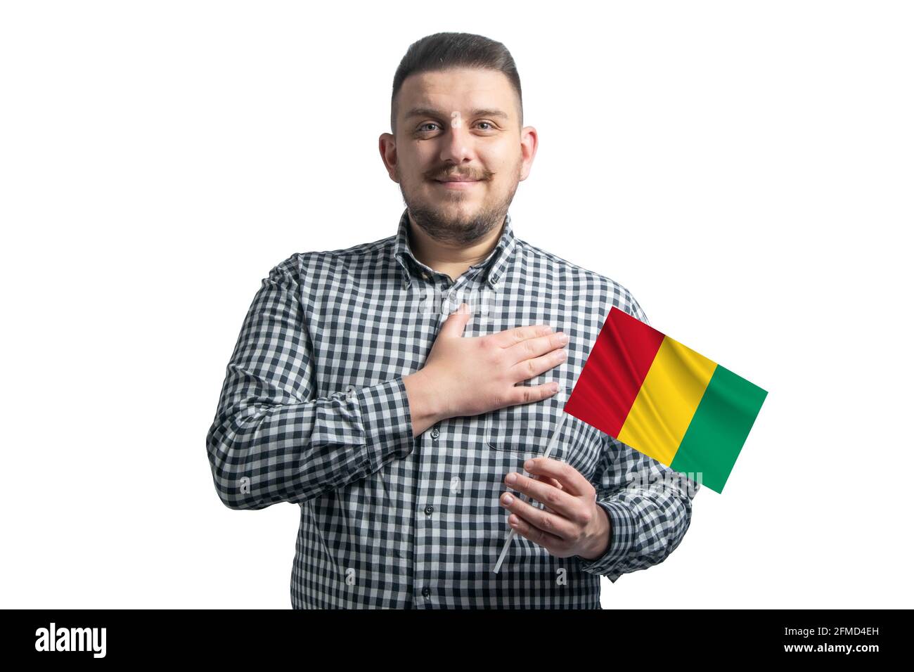 White guy holding a flag of Guinea and holds his hand on his heart ...