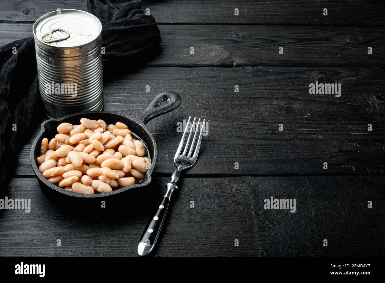 White canned kidney beans set, with metal can, in cast iron frying pan ...
