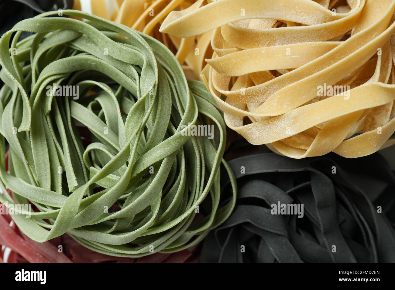Different uncooked multicolor pasta on whole background Stock Photo - Alamy