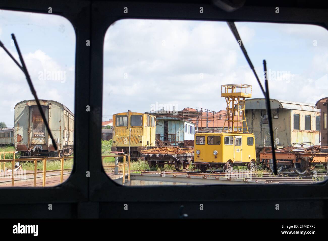 Old trains spotted behind an electric locomotive window in a vintage ...