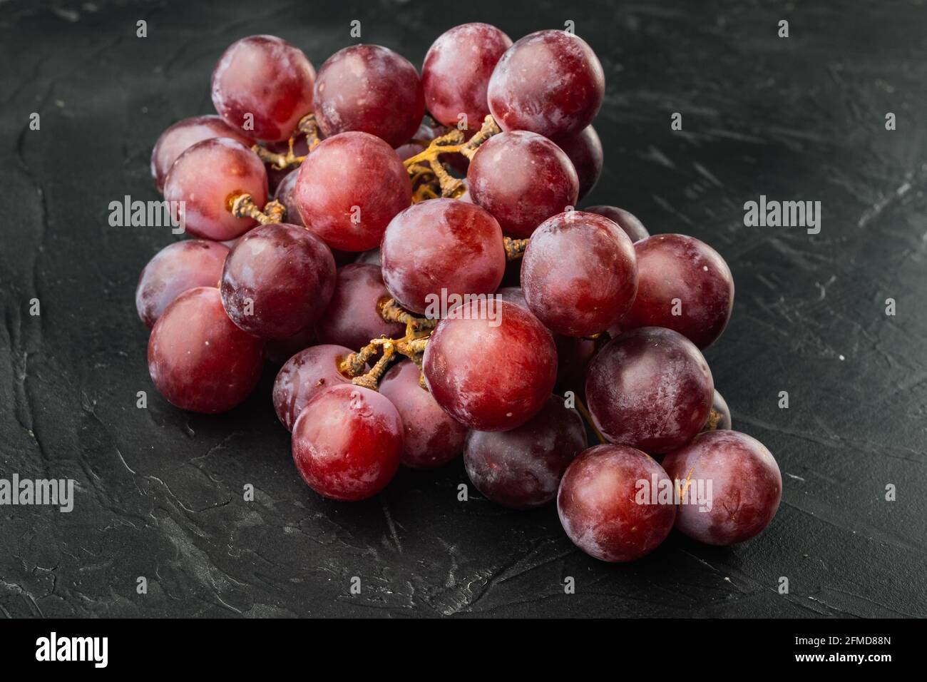 Red and white grapes set, dark red fruits, on black stone background ...
