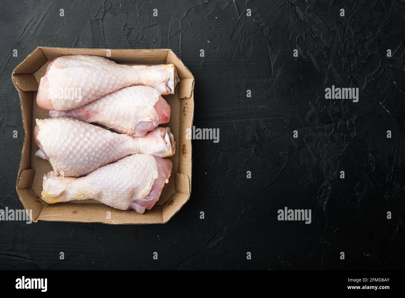 Family pack of fresh chicken legs set, in paper Pack, on black stone ...