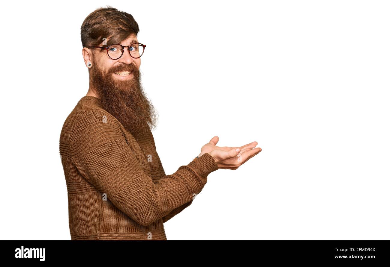 Young irish redhead man wearing casual clothes and glasses pointing ...