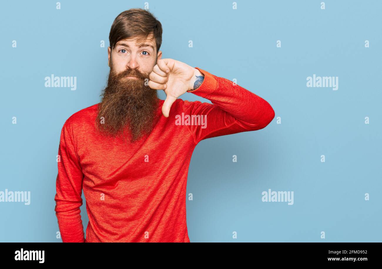 Redhead man with long beard wearing casual clothes looking unhappy and ...