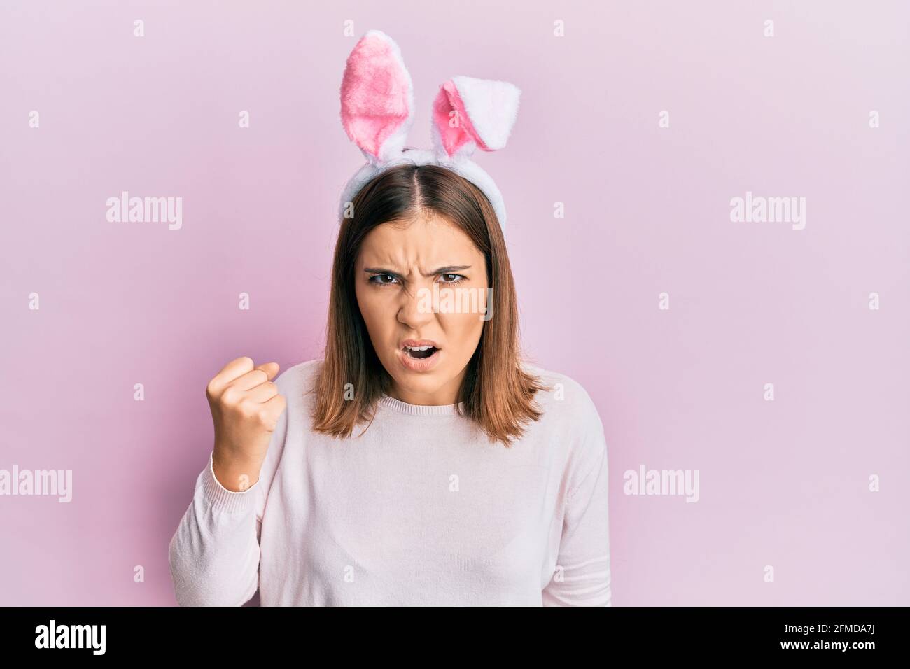 Young beautiful woman wearing cute easter bunny ears angry and mad ...