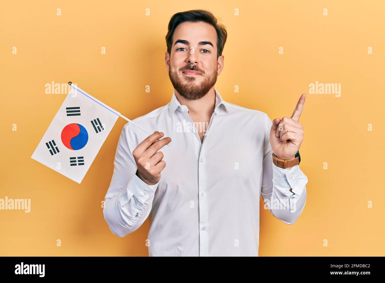 Handsome caucasian man with beard holding south korea flag smiling ...