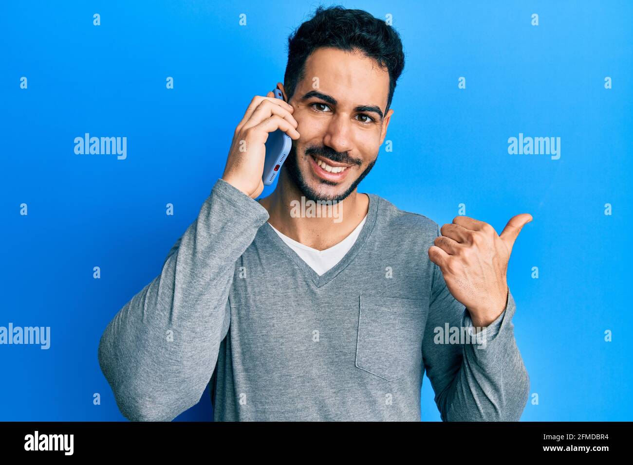 Young hispanic man having conversation talking on the smartphone ...