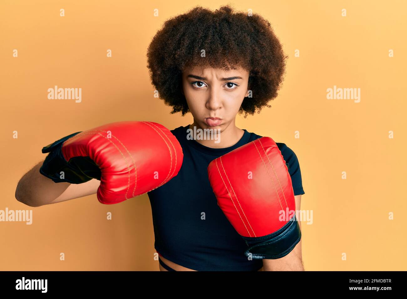 Young hispanic sporty girl using boxing gloves depressed and worry for ...