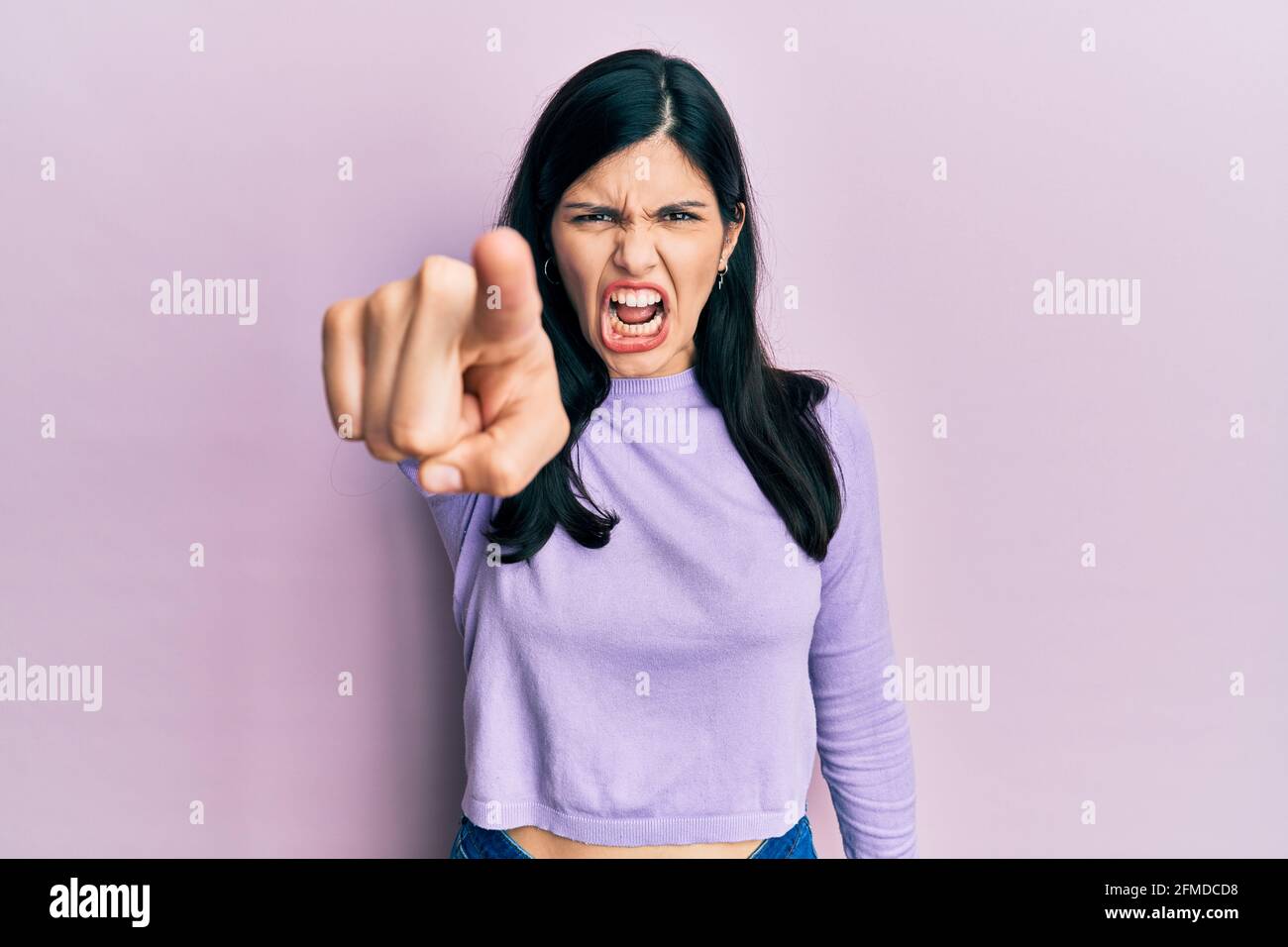 Young hispanic woman wearing casual clothes pointing displeased and ...
