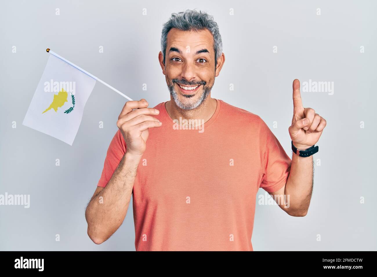 Handsome middle age man with grey hair holding cyprus flag smiling with ...