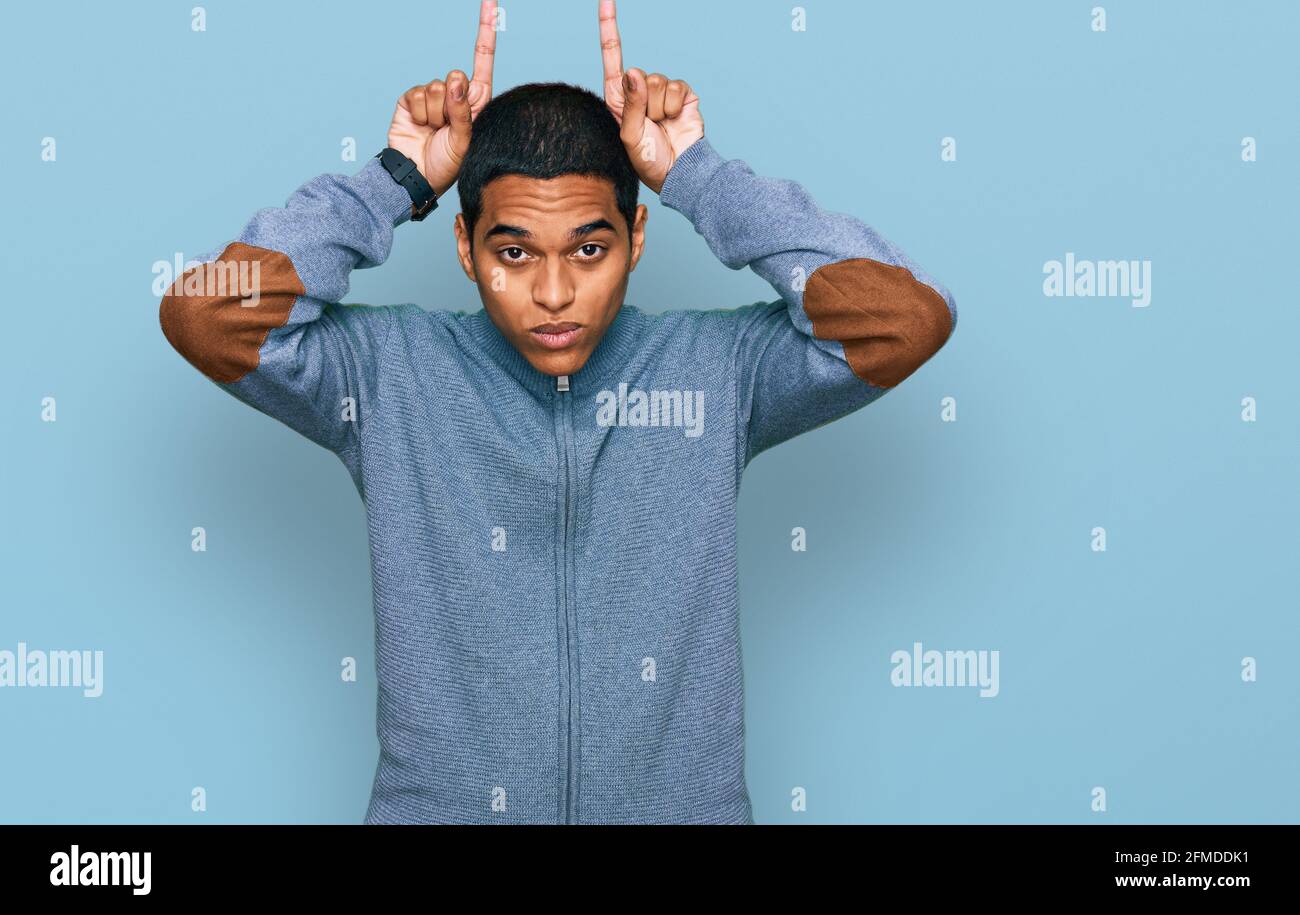 Young handsome hispanic man wearing casual sweatshirt doing funny ...