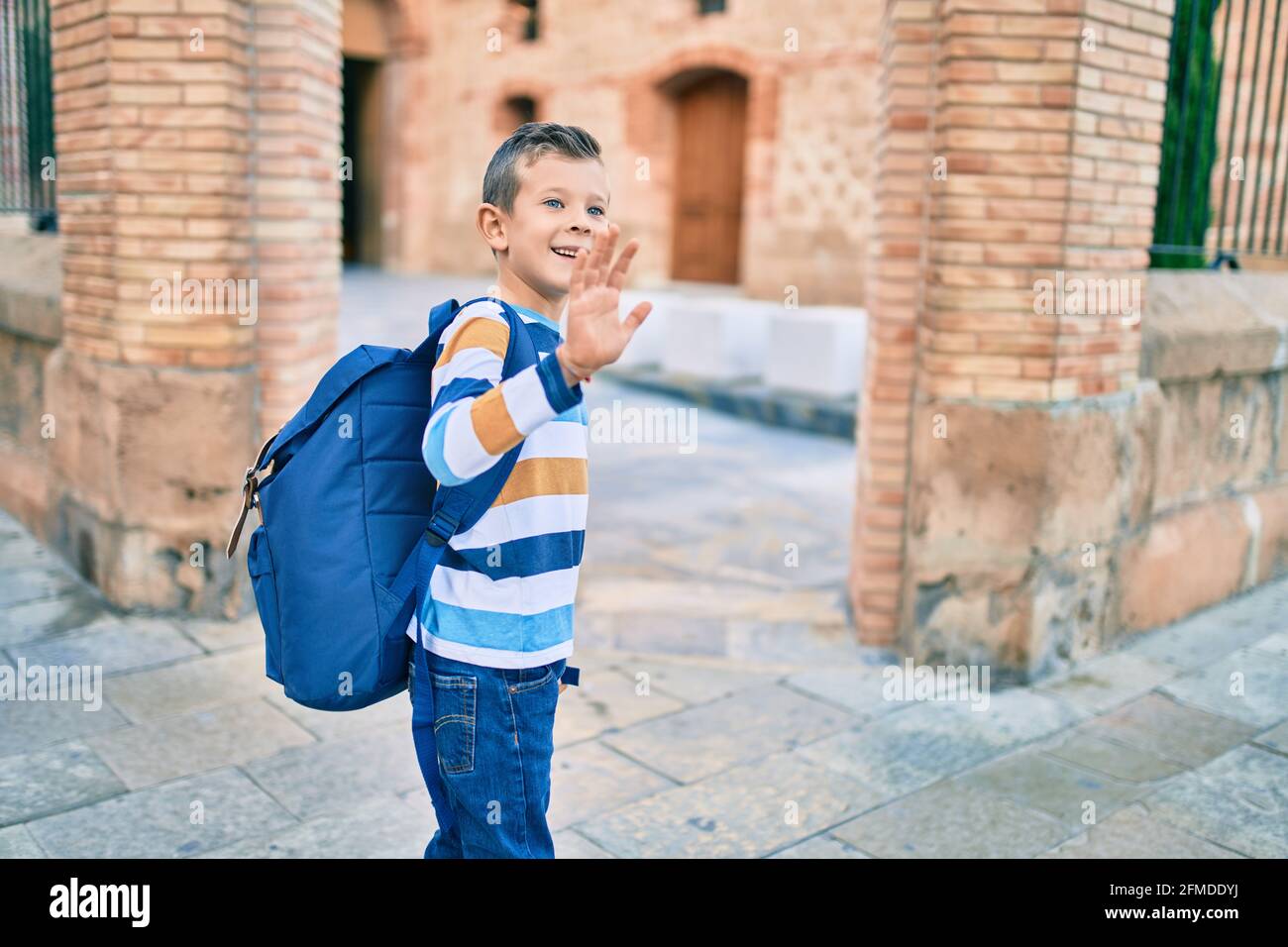 Adorable caucasian student boy smiling happy saying goodbye with hand ...