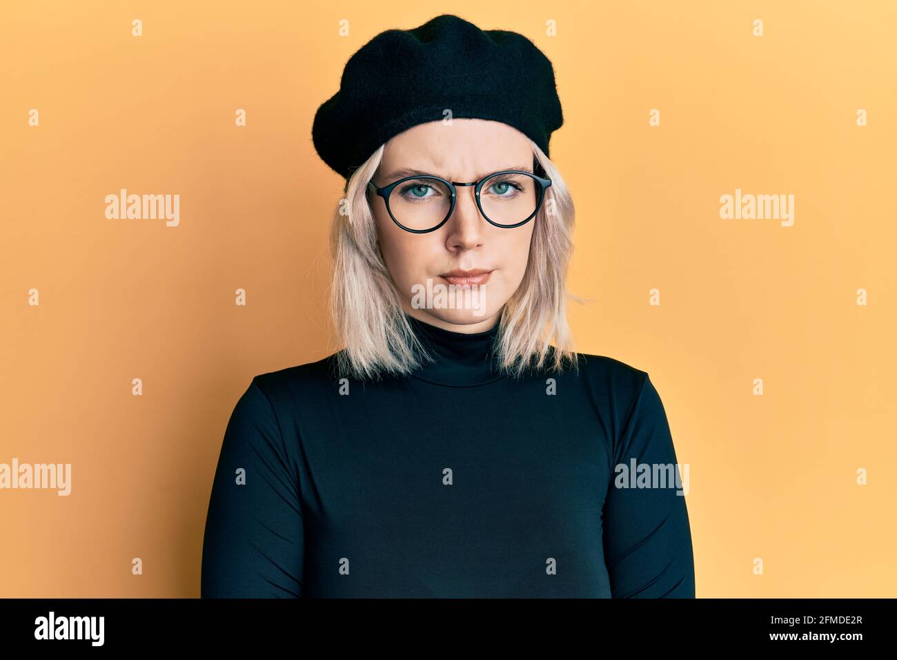 Young blonde girl wearing french look with beret skeptic and nervous ...