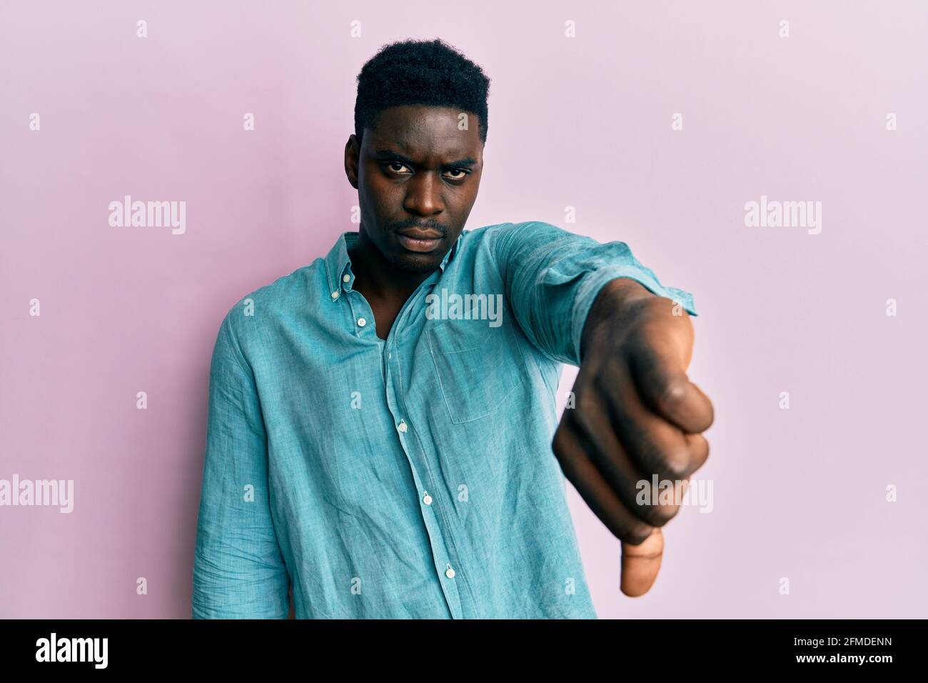 Handsome black man wearing casual clothes looking unhappy and angry ...