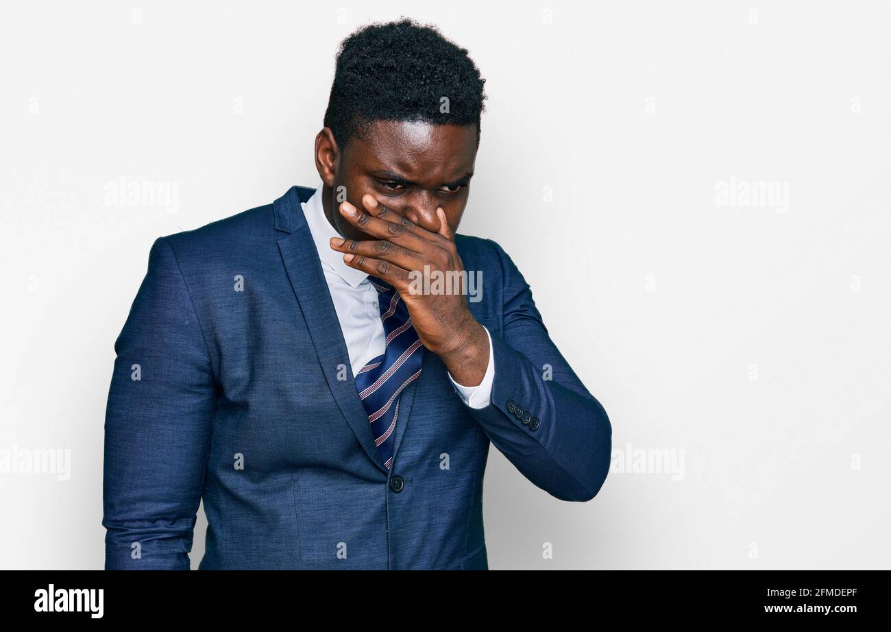 Handsome business black man wearing business suit and tie smelling ...