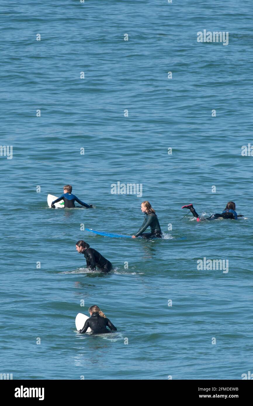 Surfers floating in the sea waiting for a wave at Fistral in Newquay in ...